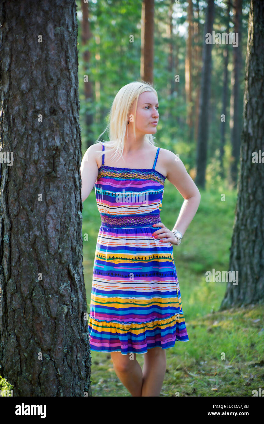 Woman in lined dress behind pine tree stem Stock Photo - Alamy