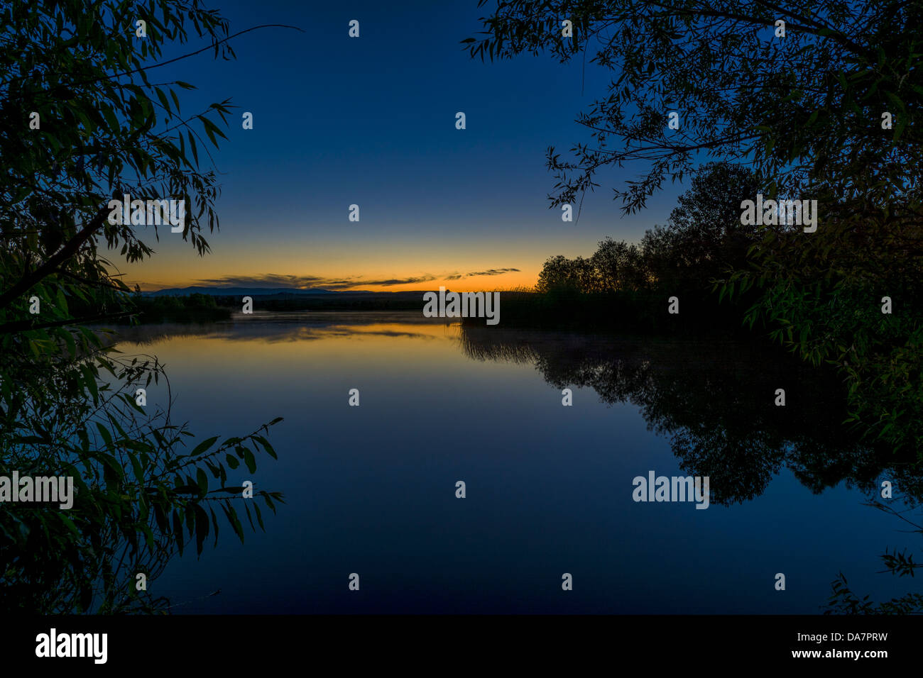 Orange sky of the first morning light over a desert lake Stock Photo ...