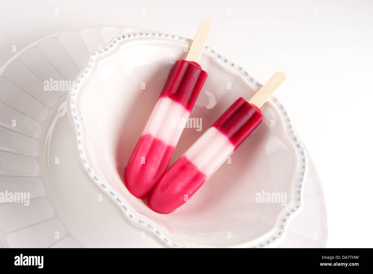 Two mulit-colored popsicles in white bowl Stock Photo - Alamy
