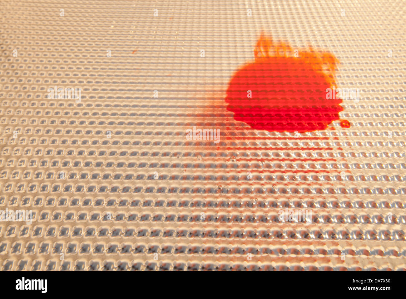 An abstract of bright red splattered liquid spreading out against a ...