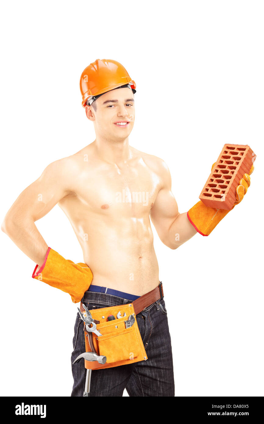 Shirtless muscular male construction worker with helmet holding a brick ...