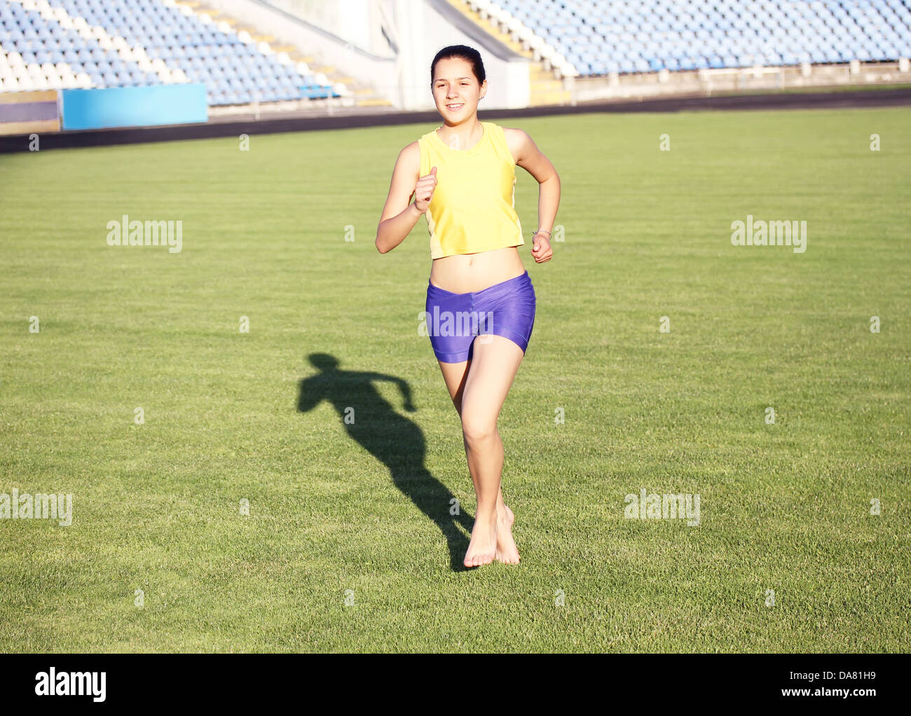 Beautiful teenage sport girl running on the grass Stock Photo - Alamy