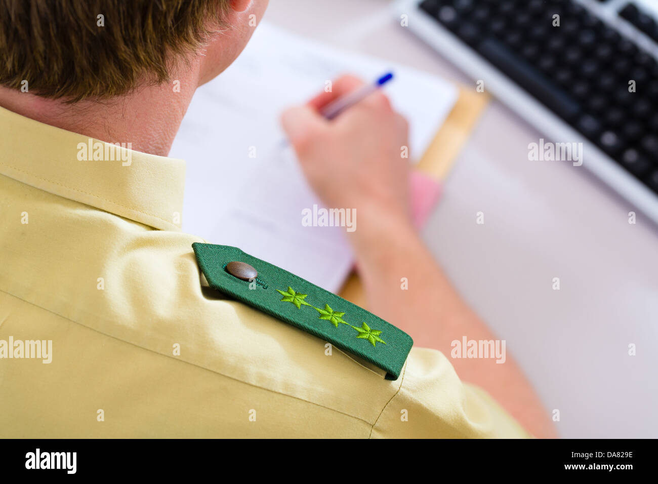Police officer in police station working on the computer, on a case or ...