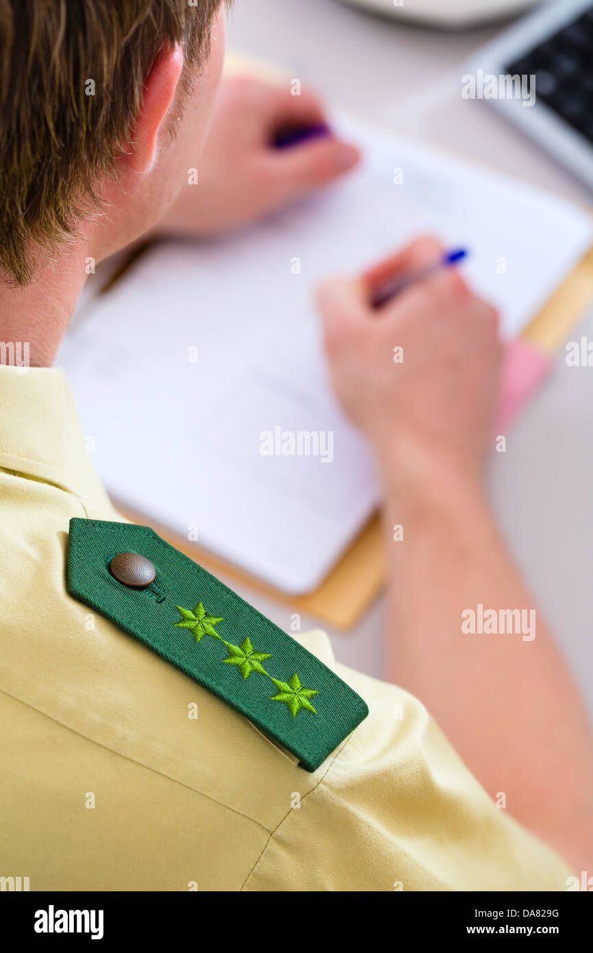 Police officer in police station working on the computer, on a case or ...