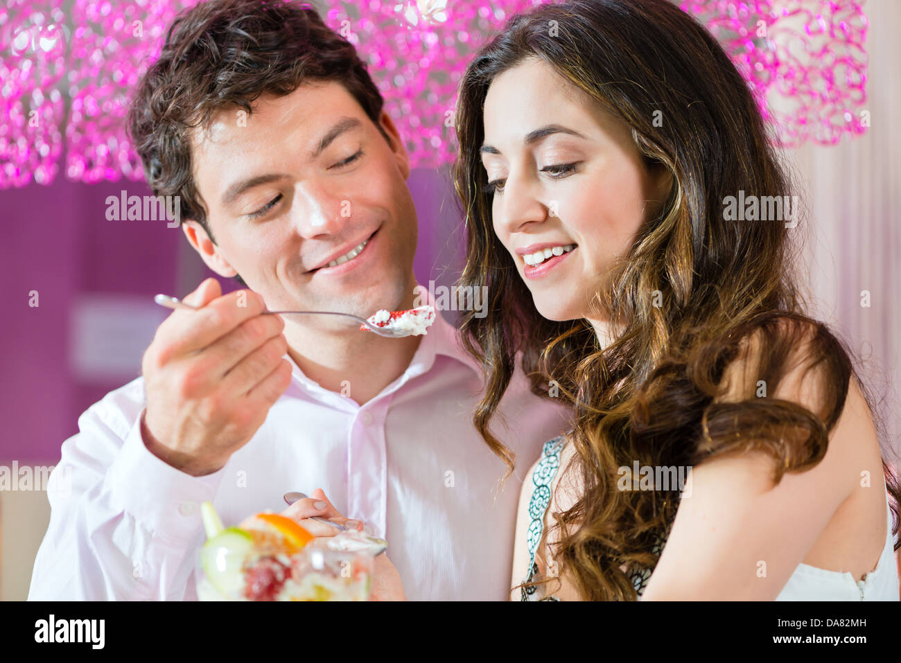 Young Couple in a Cafe or Ice cream parlor, eating an ice cream sundae ...