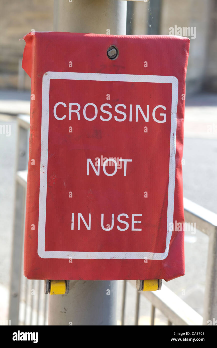 Pedestrian crossing with a red and white covering saying "Crossing not ...