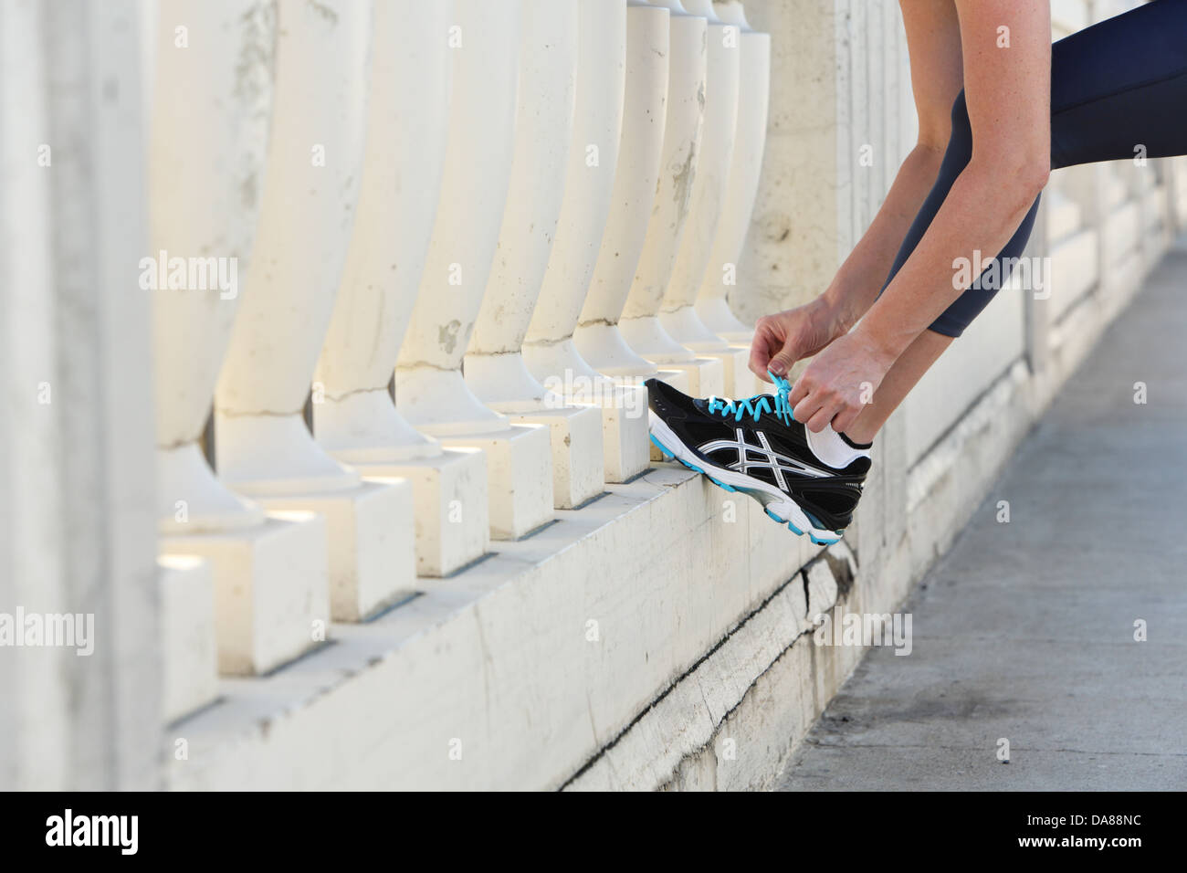 Female runner tying her shoe Stock Photo - Alamy