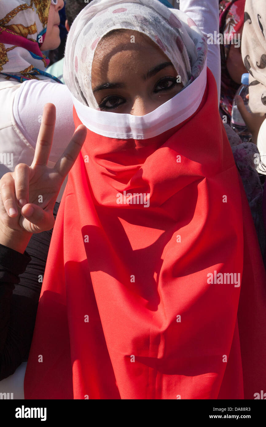 London, UK. 7th July, 2013. A young woman gives a 'V' for Victory sign ...