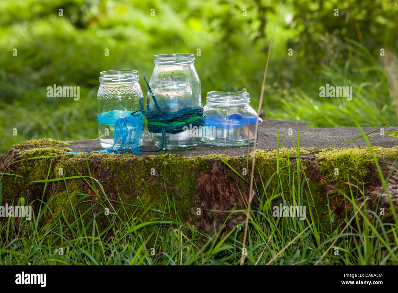 Jam jars with ribbons around them sitting on a tree stump Stock Photo ...