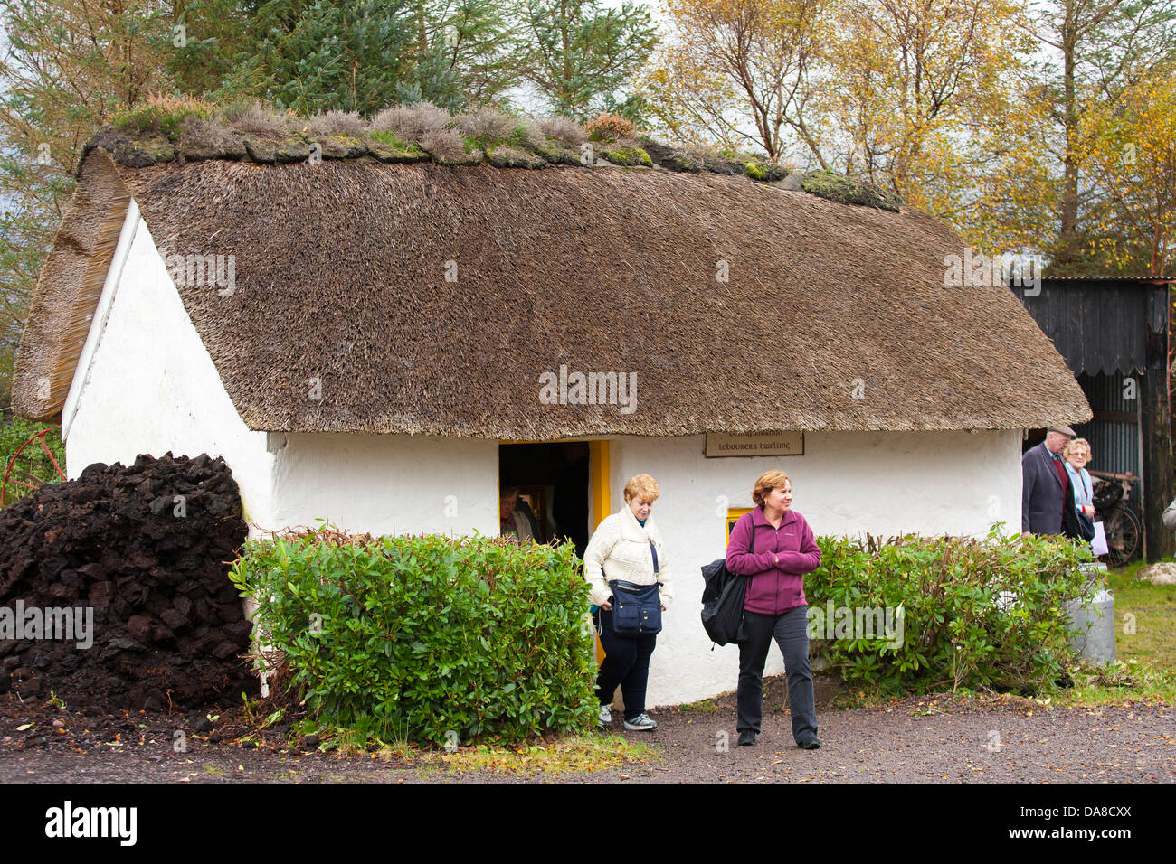 Visitors walk into a laborers cottage at the Kerry Bog Village in Co ...