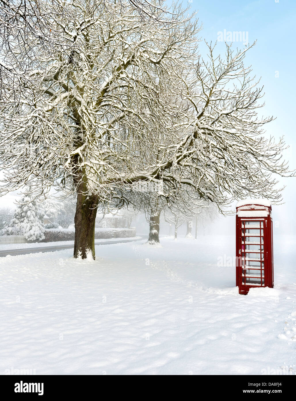 A red telephone box in Sinnington village on a sunny, snowy winter ...