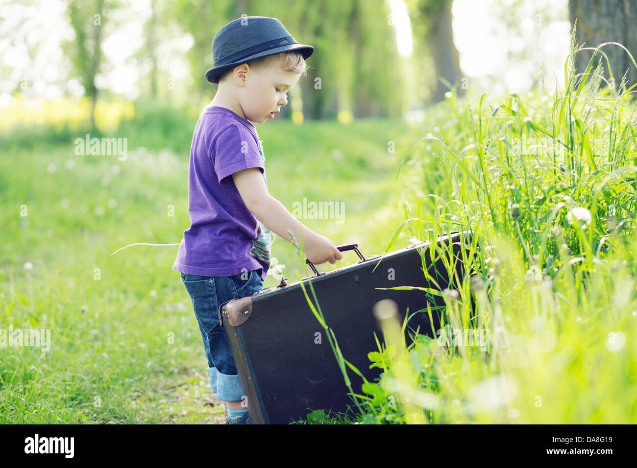 Photo of small child trying to escape with suitcase Stock Photo - Alamy