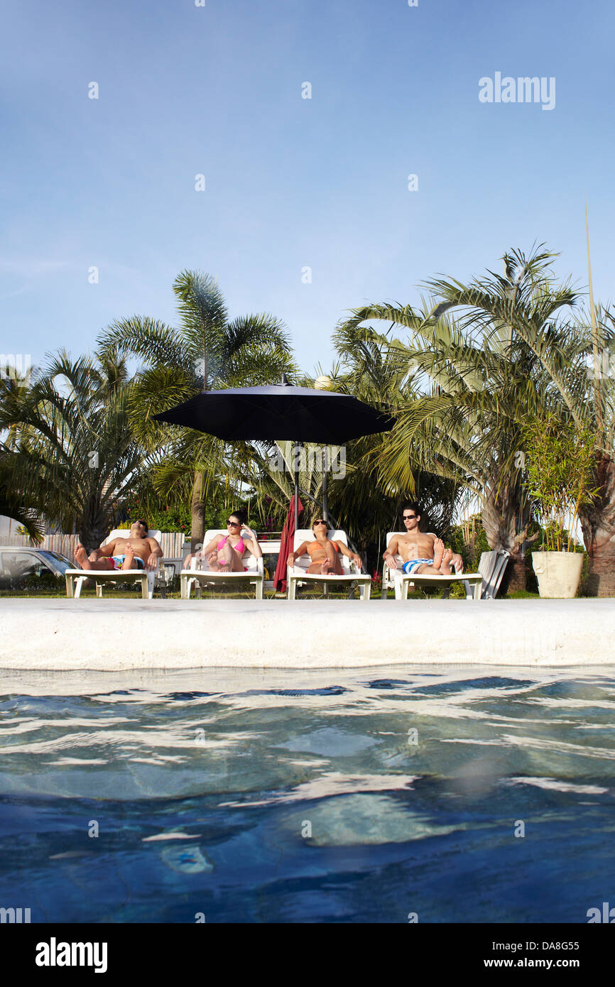 Friends relaxing poolside Stock Photo - Alamy
