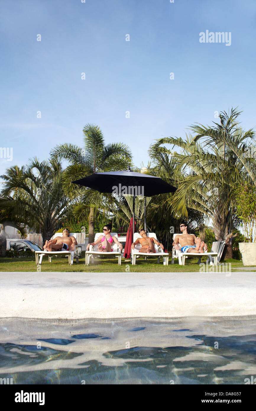 Friends relaxing poolside Stock Photo - Alamy