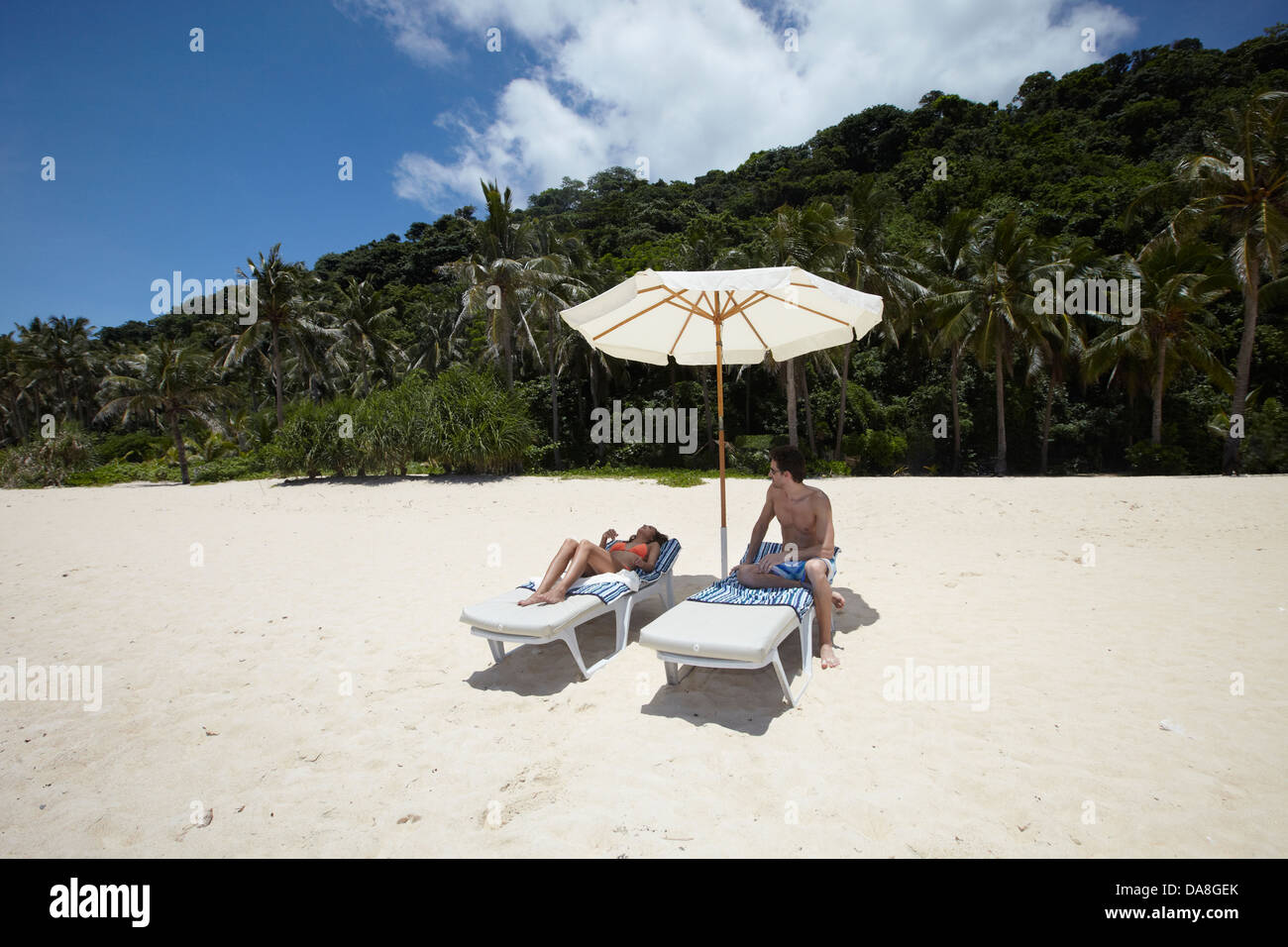 A couple sunbathing on a beach Stock Photo - Alamy