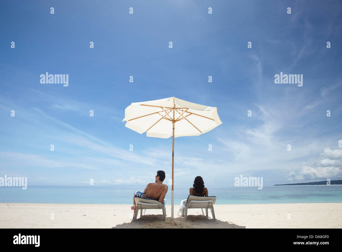 A couple sunbathing on a beach Stock Photo - Alamy