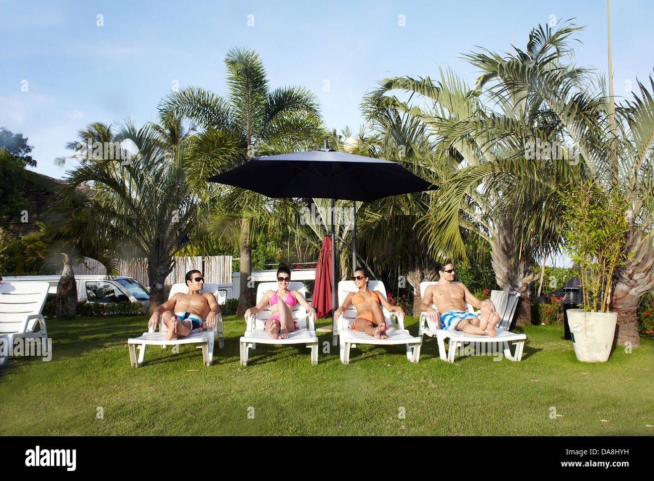 Friends relaxing poolside Stock Photo - Alamy