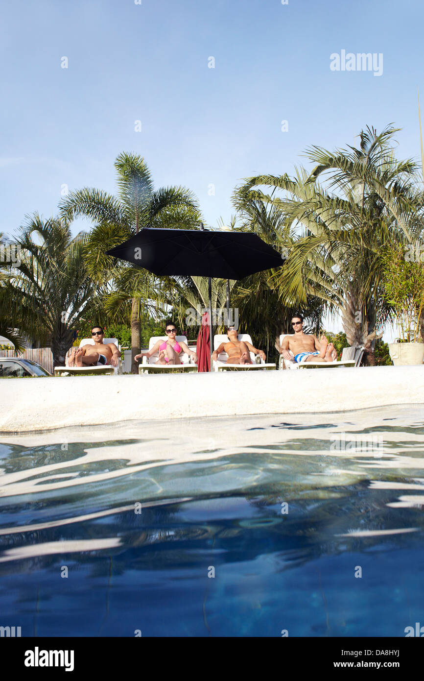 Friends relaxing poolside Stock Photo - Alamy