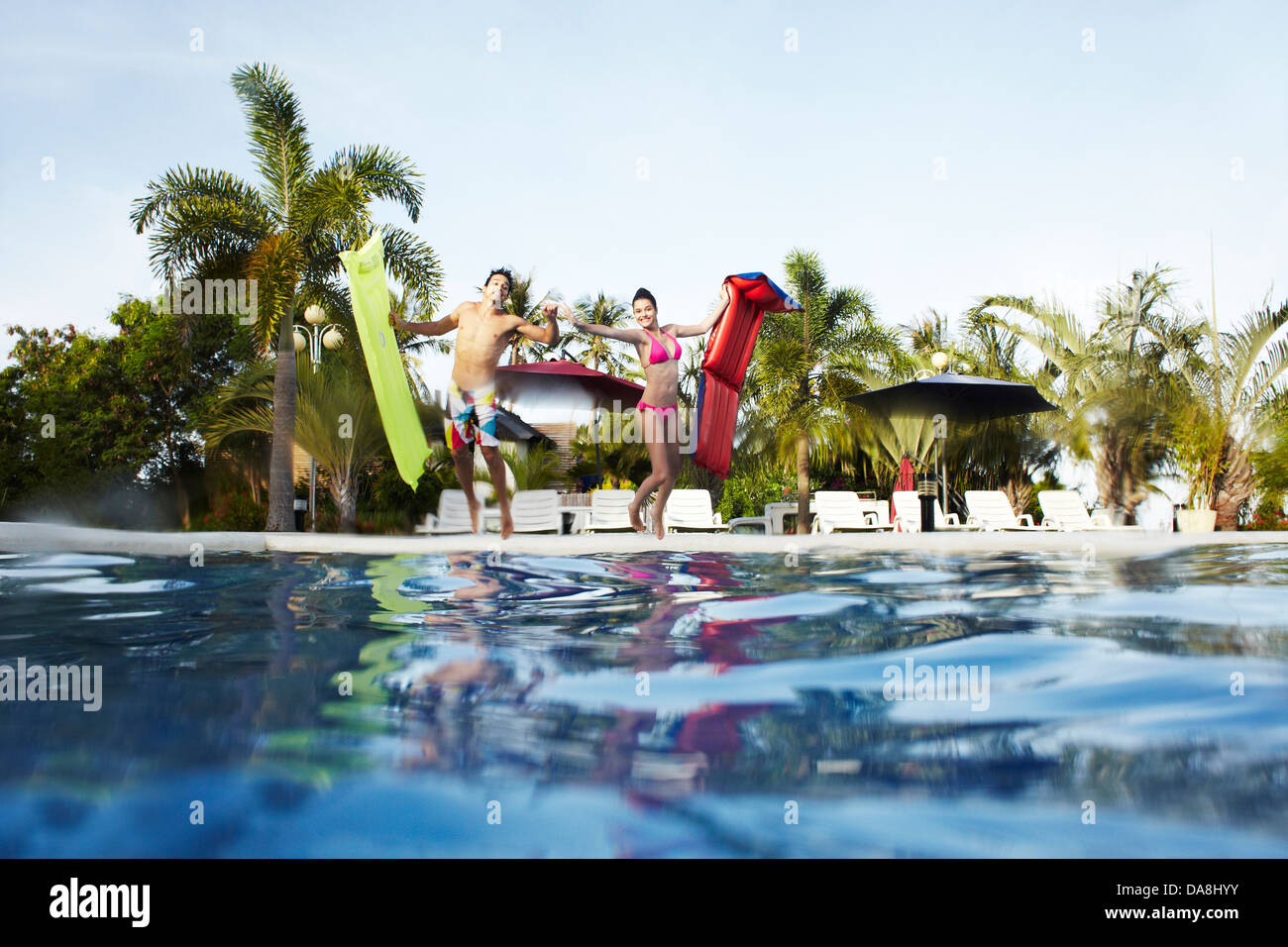 Friends playing in a swimming pool Stock Photo - Alamy