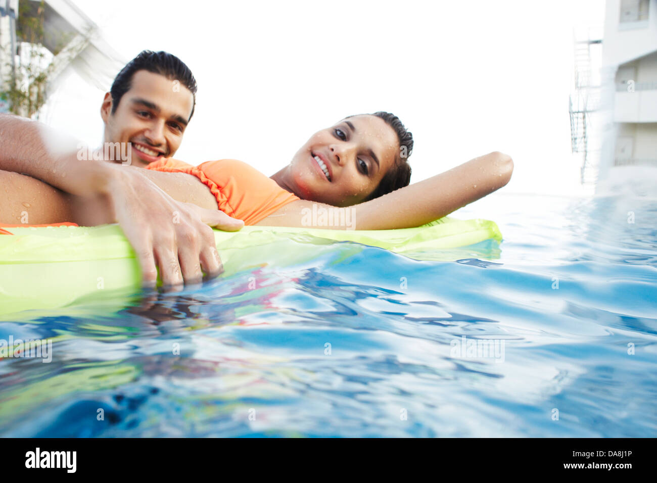 Friends playing in a swimming pool Stock Photo - Alamy