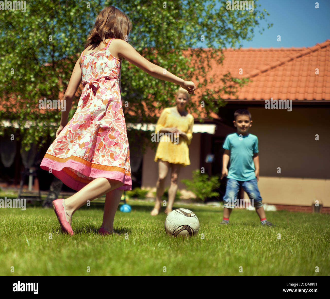 Happy family playing football in their garden Stock Photo - Alamy