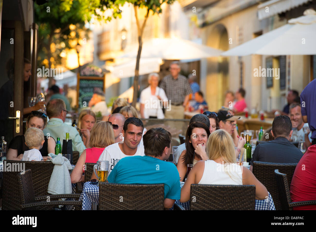 Friends dining outside a bar in the Old Town area of Alcudia, Mallorca ...