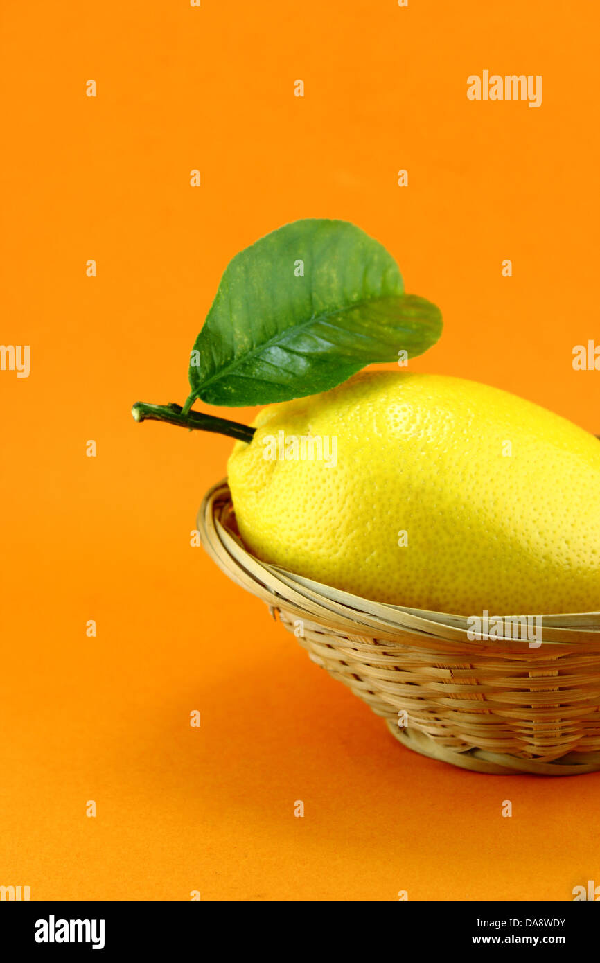 yellow ripe lemon with leaf over the orange background Stock Photo - Alamy