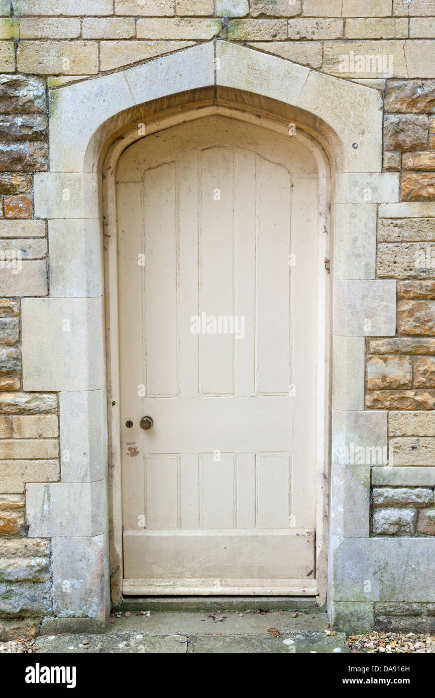 Weathered exterior door set in a buff coloured stone wall Stock Photo ...