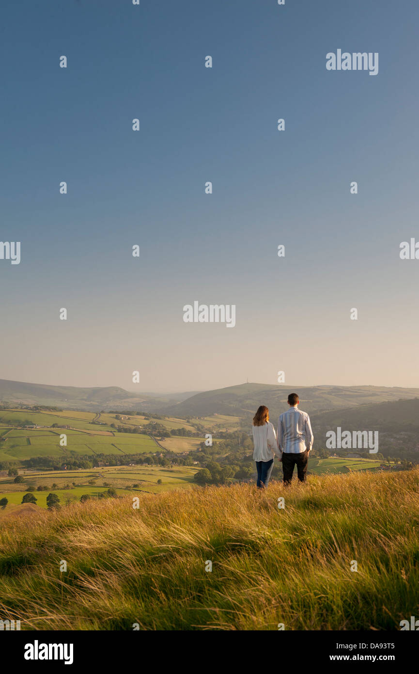 couple looking over a valley to hills beyond on Saddleworth moor ...