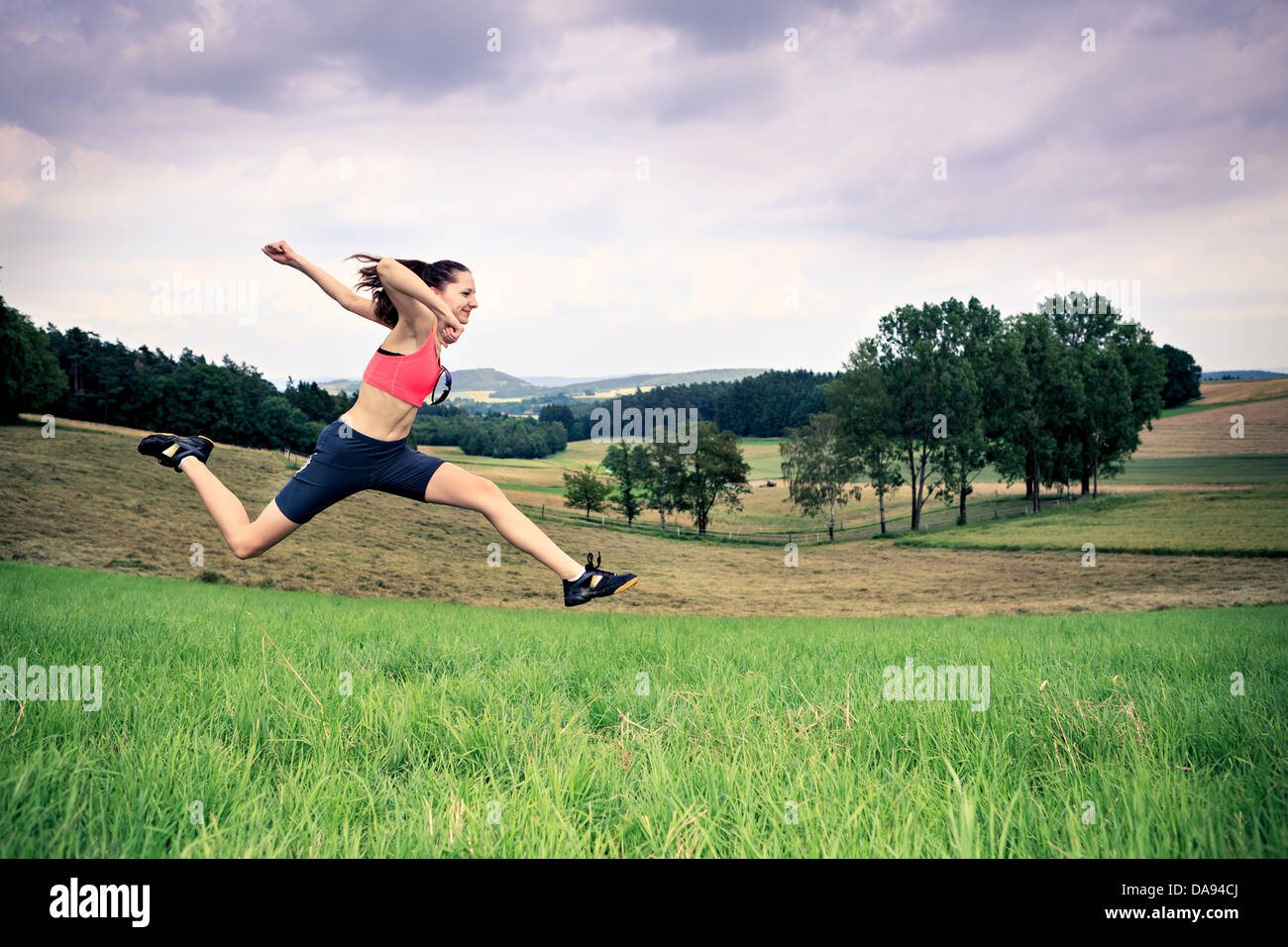 young woman jogging in front of cross country Stock Photo - Alamy
