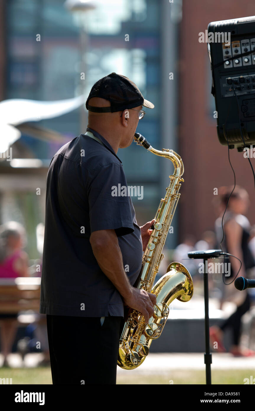 Male busker playing saxophone hi-res stock photography and images - Alamy