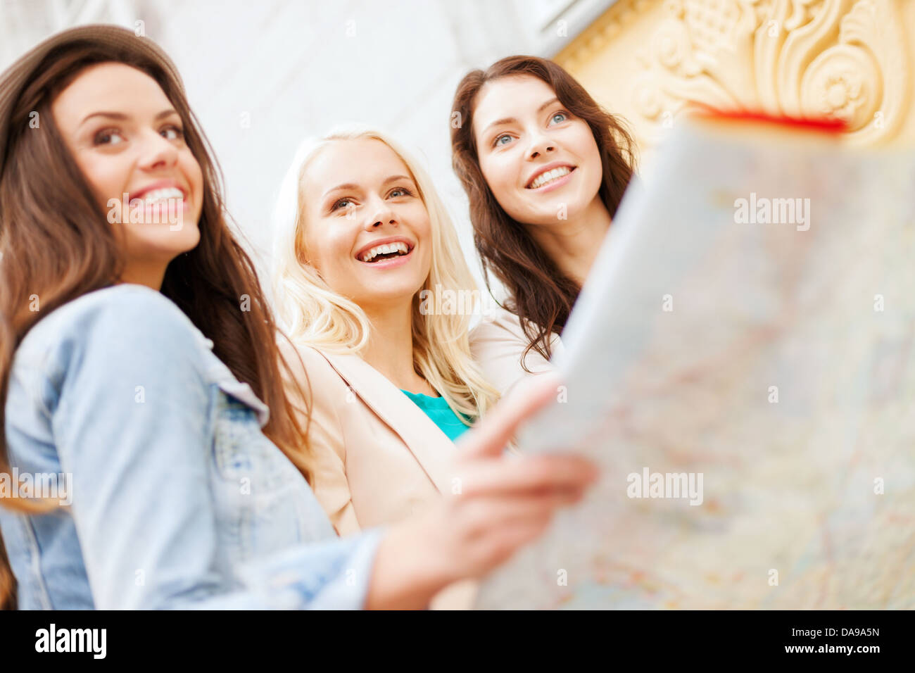 beautiful girls looking into tourist map in city Stock Photo - Alamy