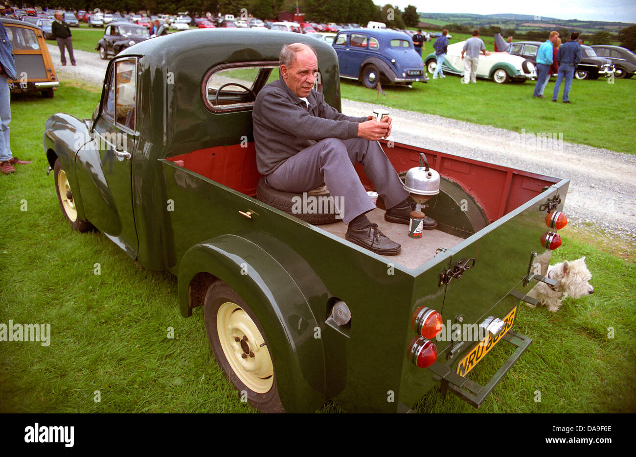 An exhibitor relaxes with a cuppa in the back of his Morris 1000 during ...