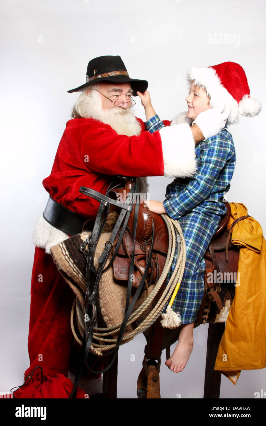 Santa and a little cowboy exchanging hats Stock Photo - Alamy