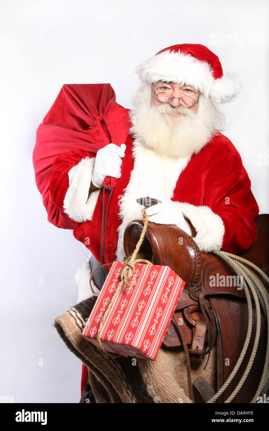 Santa Claus standing next to a western saddle and presents Stock Photo ...