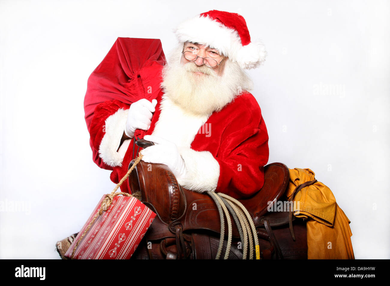 Santa Claus standing next to a western saddle and presents Stock Photo ...