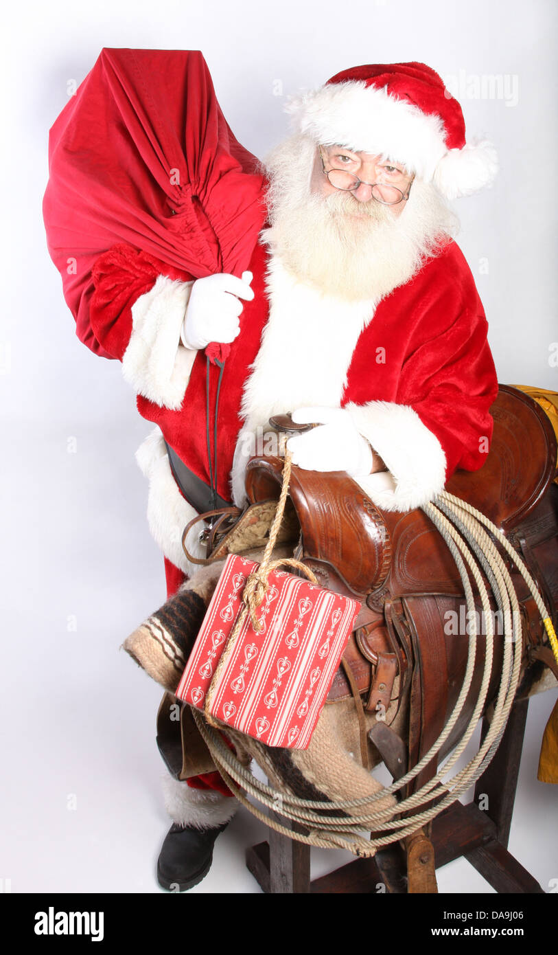 Santa Claus standing next to a western saddle and presents Stock Photo ...