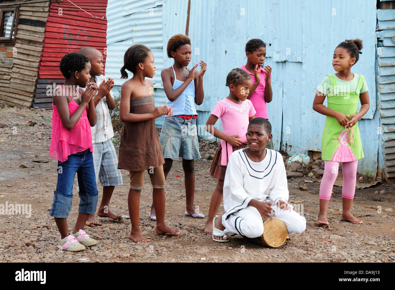 Boy young man playing traditional south African drum and a group of ...