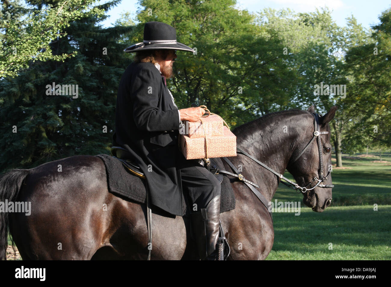A cowboy delivering presents at Christmas time on horseback Stock Photo ...