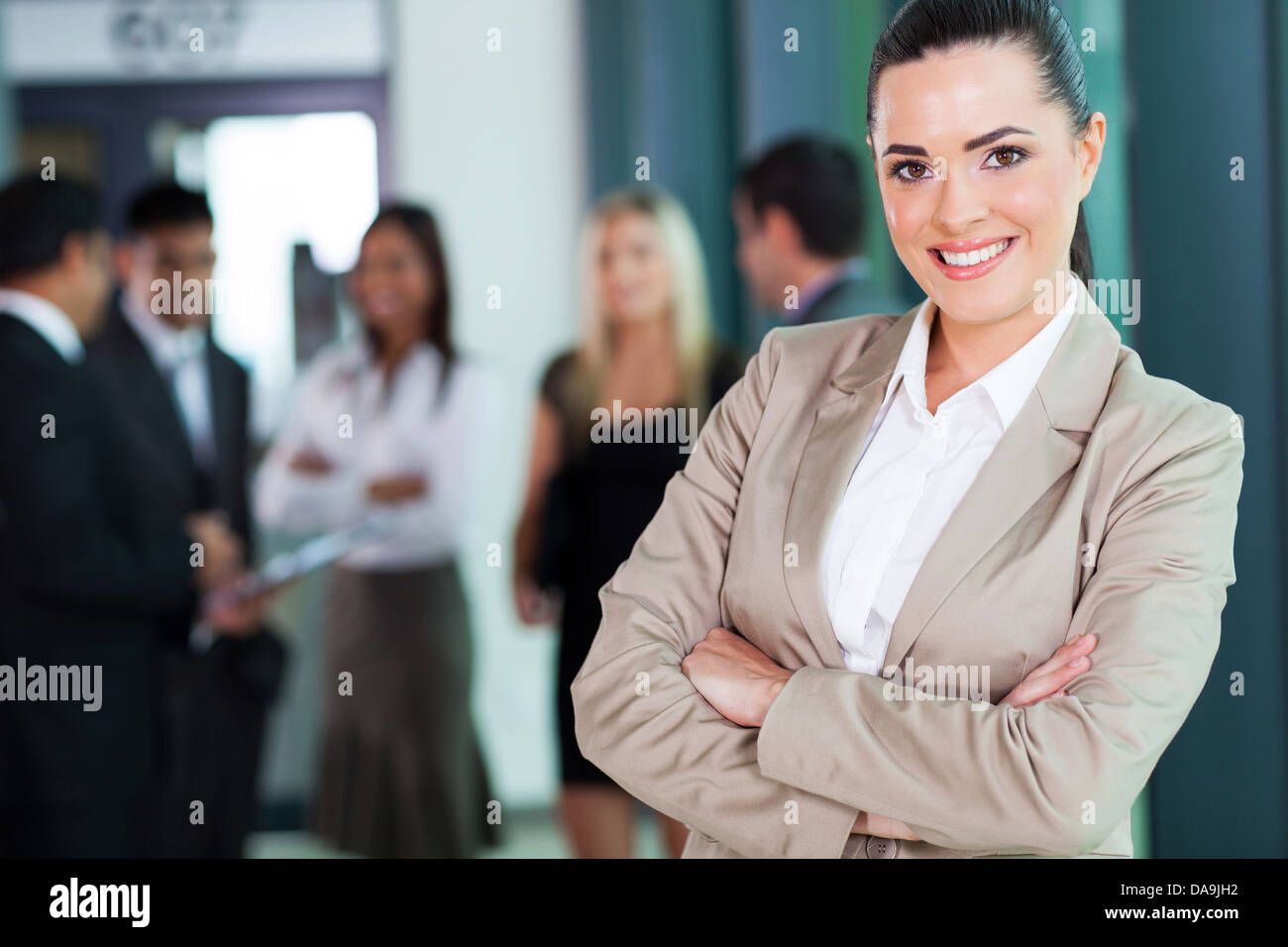 attractive female business executive with arms crossed in boardroom ...