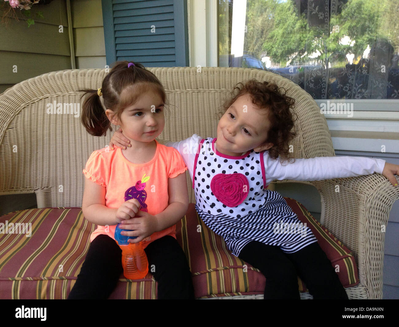 Two cousins on wicker sofa Stock Photo - Alamy