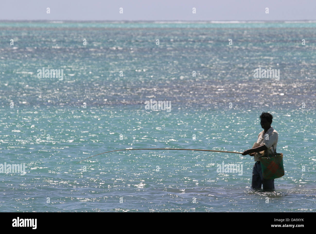 A local man standing in the sea fishing in Mauritius Stock Photo - Alamy