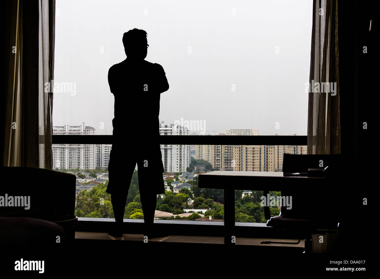 Man looking out a window Stock Photo - Alamy