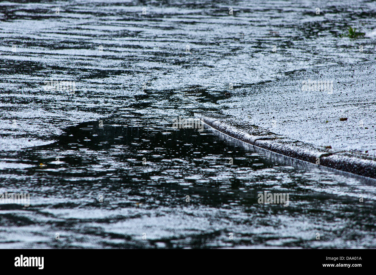 Heavy rain in gutter and road Stock Photo - Alamy