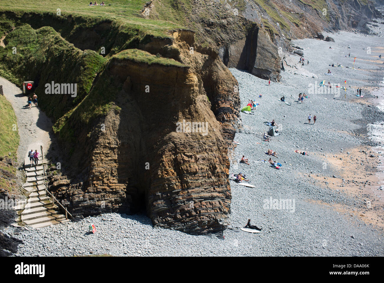 People on the beach of Sandymouth Bay, north Devon, England, as seen ...
