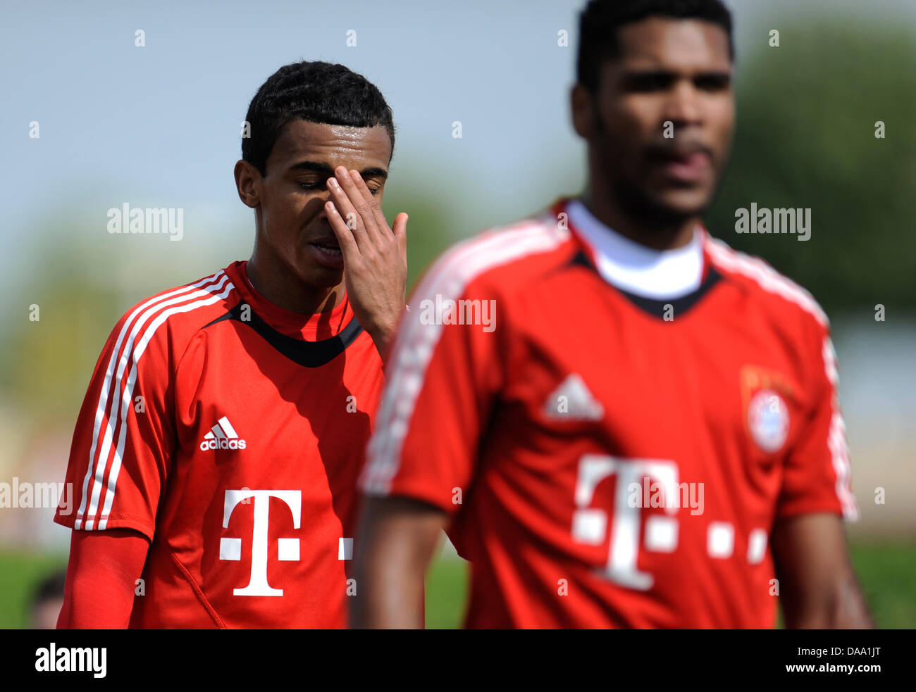 FC Bayern Munich's newcomer Luiz Gustavo (L) touches his nose behind ...
