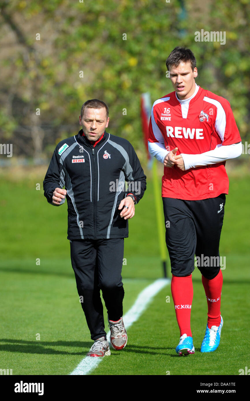 Cologne's player Christopher Schorch (R) runs across the pitch next to ...