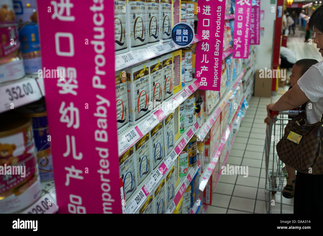 An elderly woman and a baby look at imported infant formula baby milk ...