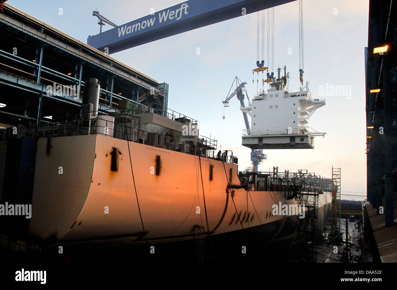 The 600-tons deckhouse of a new container ship is lifted onto its place ...