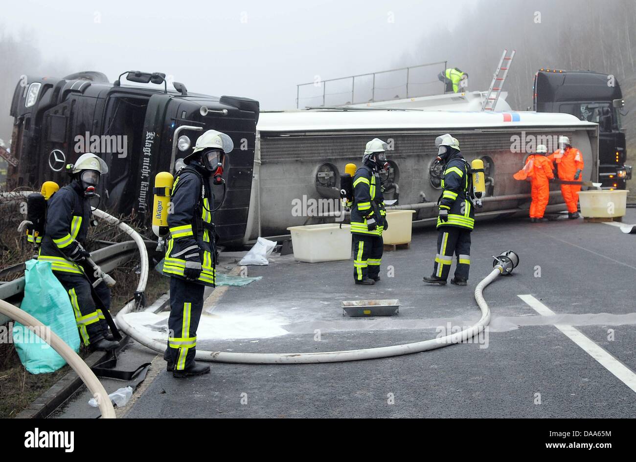 Firefighters empty a crashed tank lorry on autobahn A66 near Steinau ...